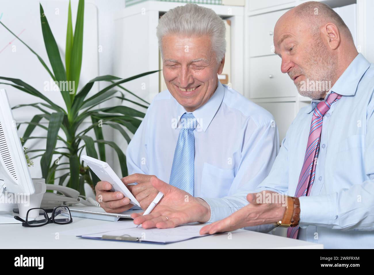 Two old business men sitting at desk and working Stock Photo - Alamy