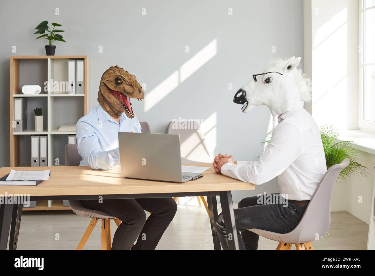 Strange people in funny animal masks having a business meeting or a job ...