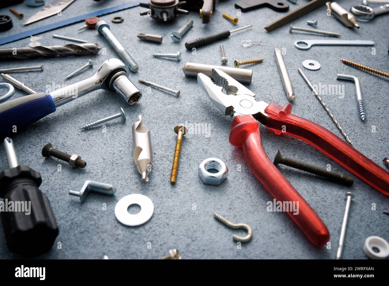Close up of tools, screws and other metal hardware on a work bench ...