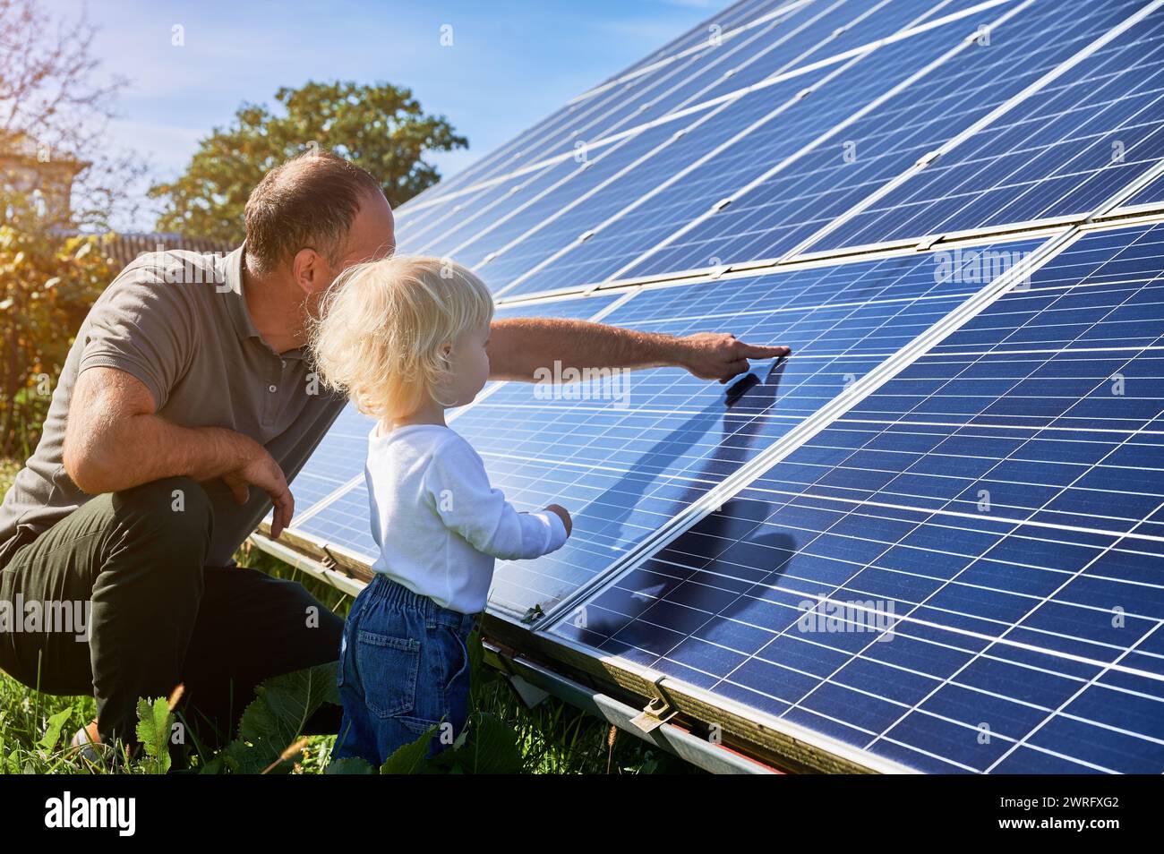 Man showing small kid the solar panels during sunny day. Father ...