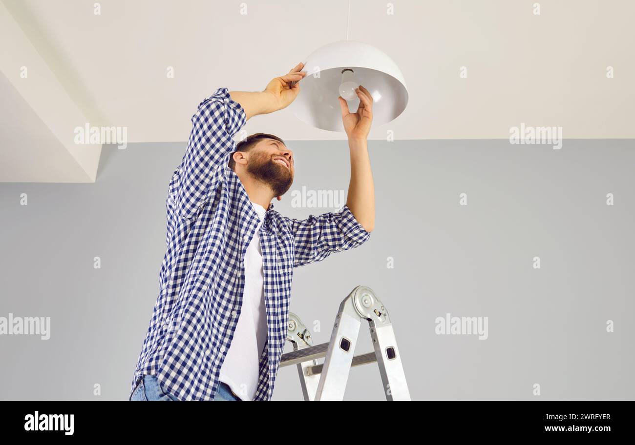 Man changing light bulb on ladder hi-res stock photography and images ...