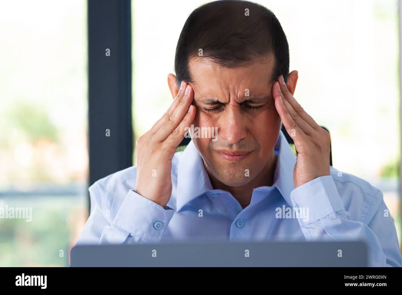 Sick executive with migraine complaining in pain rubbing temples ...