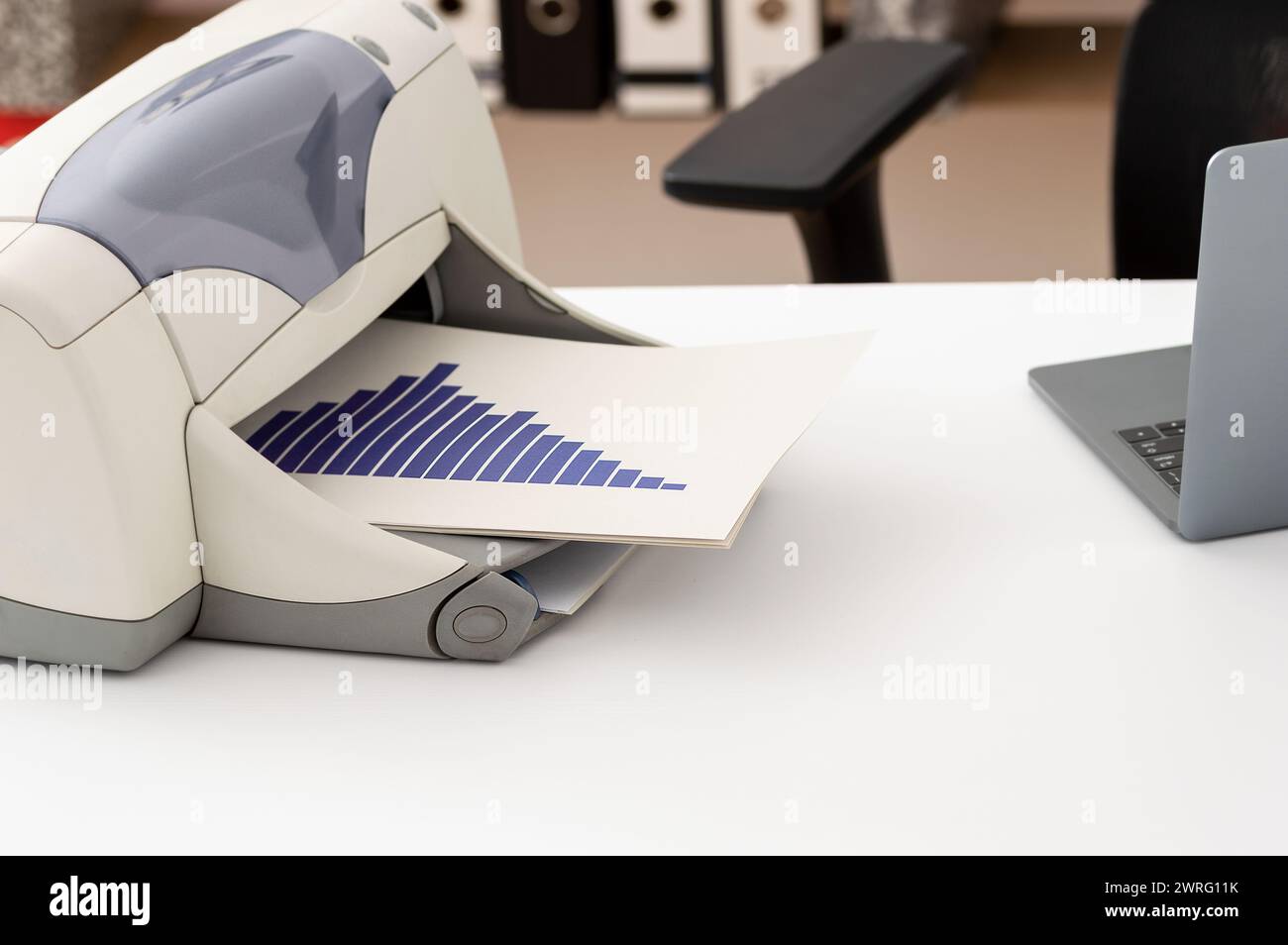 Shot of diagram sheets of paper coming out of a computer printer at ...