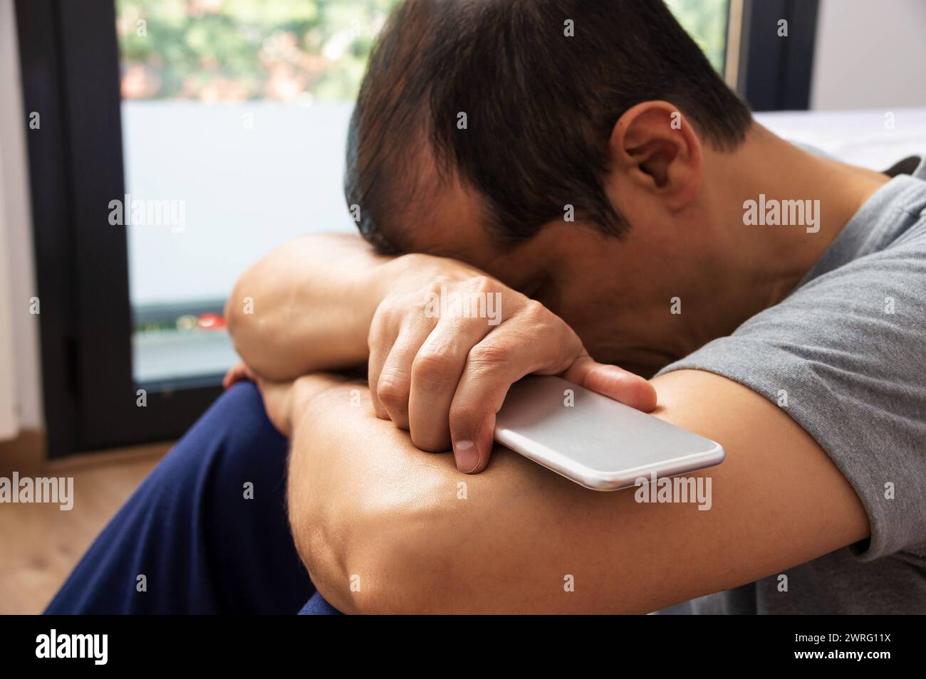 Sad man lamenting sitting hi-res stock photography and images - Alamy