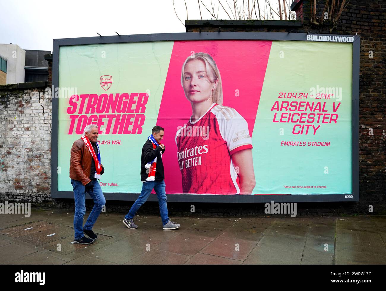 Fans walk past a billboard advertising a Arsenal Women's match ahead of ...