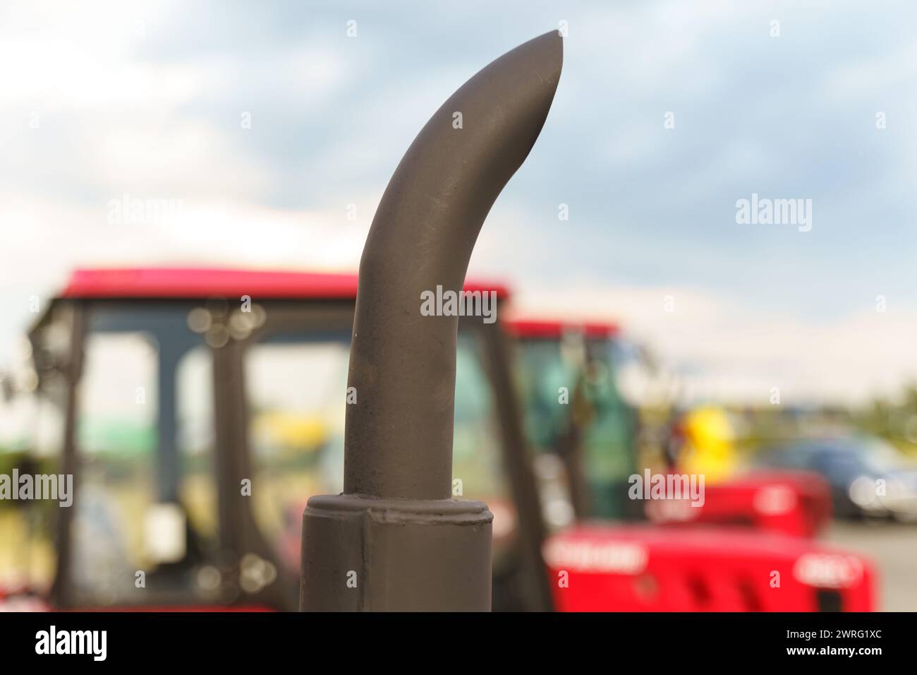 A focused view of a tractors exhaust pipe with the tractor and farm ...