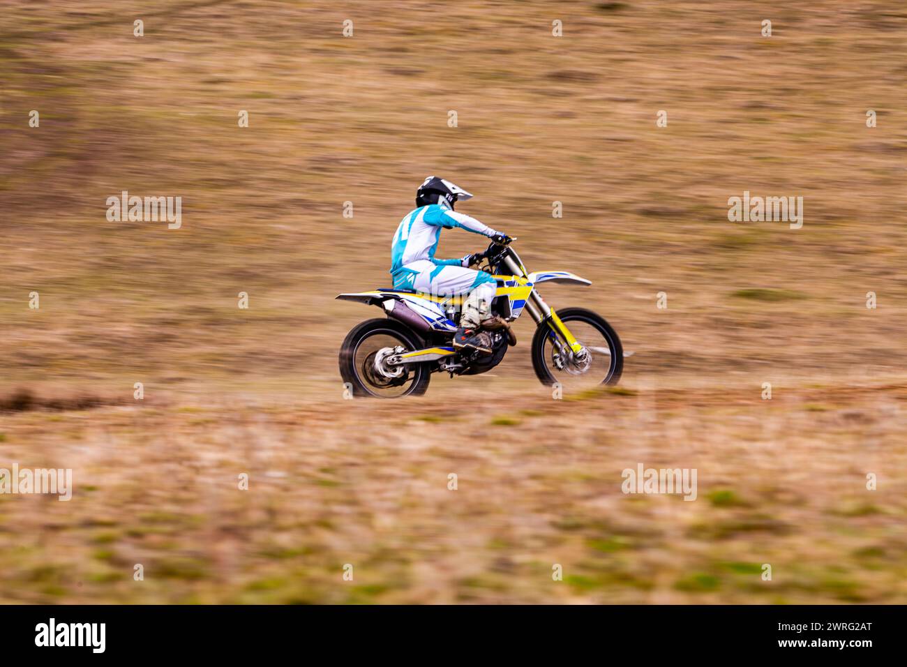 A person is descending a hill on a dirt bike with Motocross helmet ...