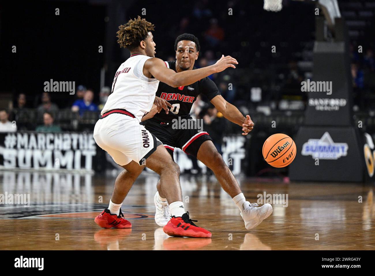 Denver Pioneers guard Tommy Bruner (0) passes the ball around a ...