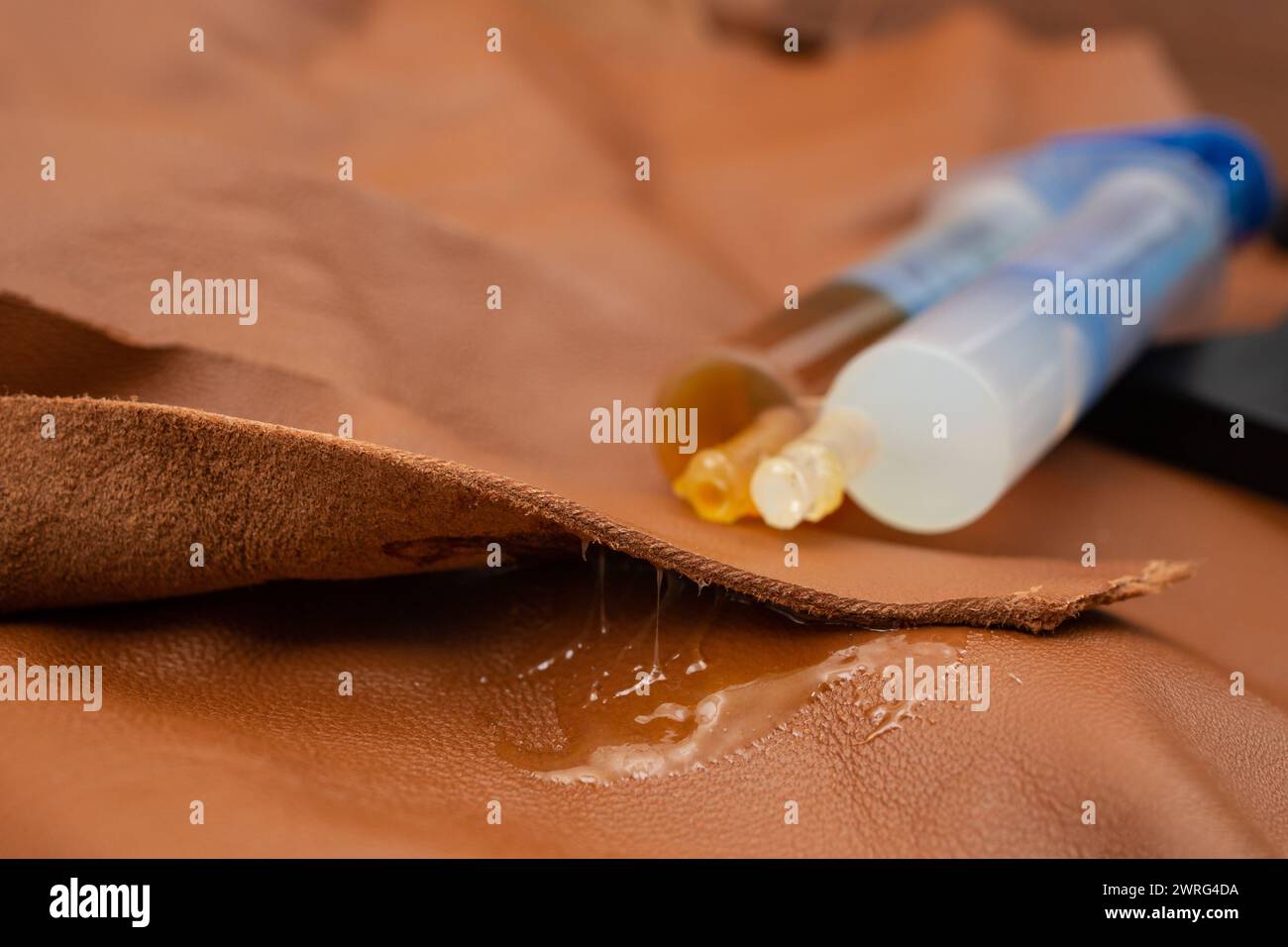 Double syringe with epoxy gel gluing and spilling on genuine brown ...