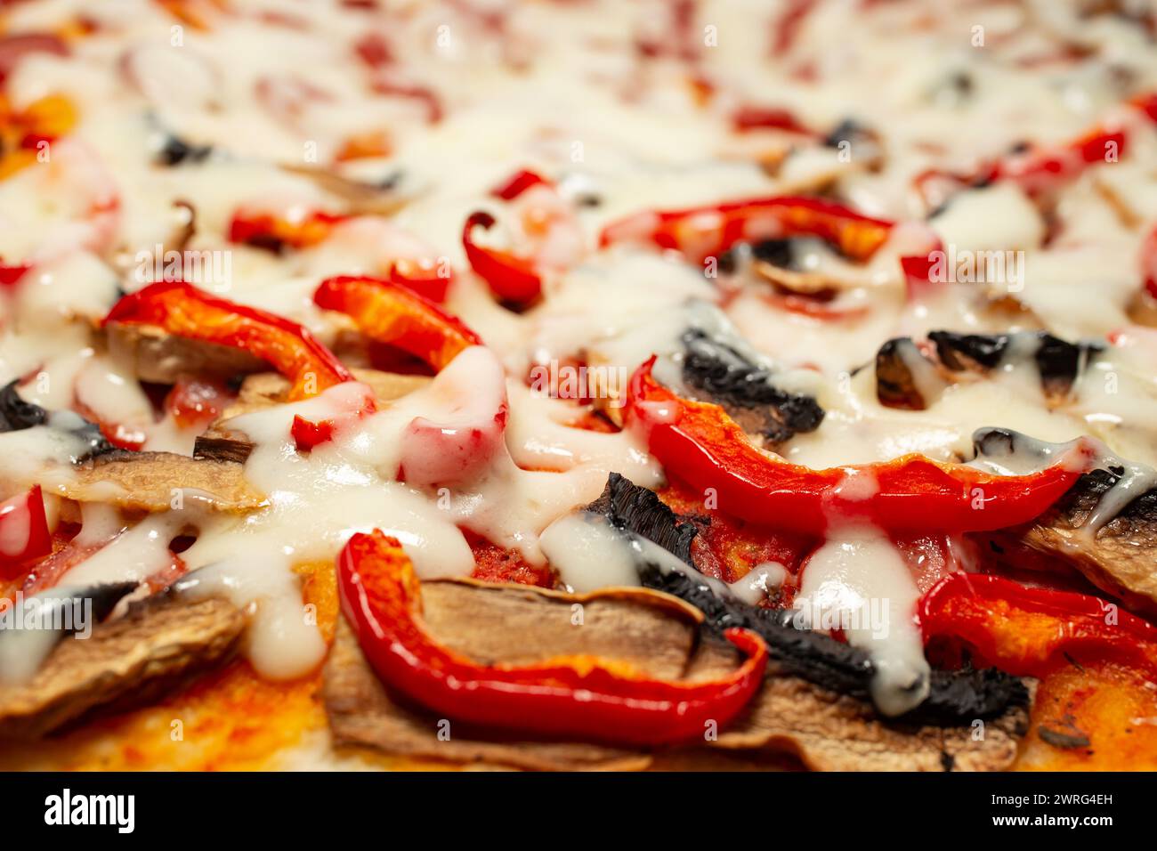 Red bell pepper pizza with melted cheese, soft focus close up ...