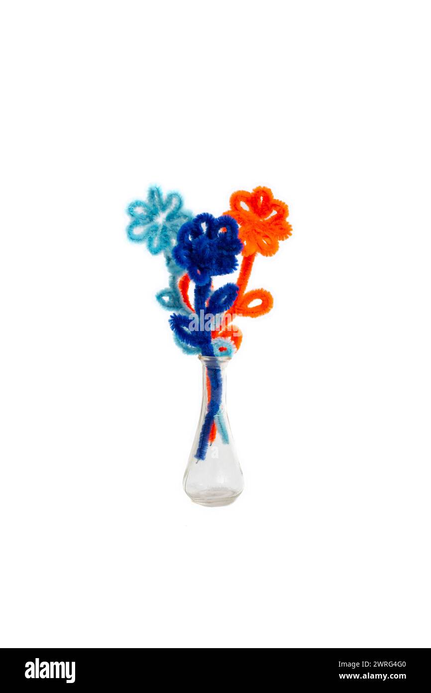 Pipe cleaner fluffy wires flowers in a glass vase isolated on white ...