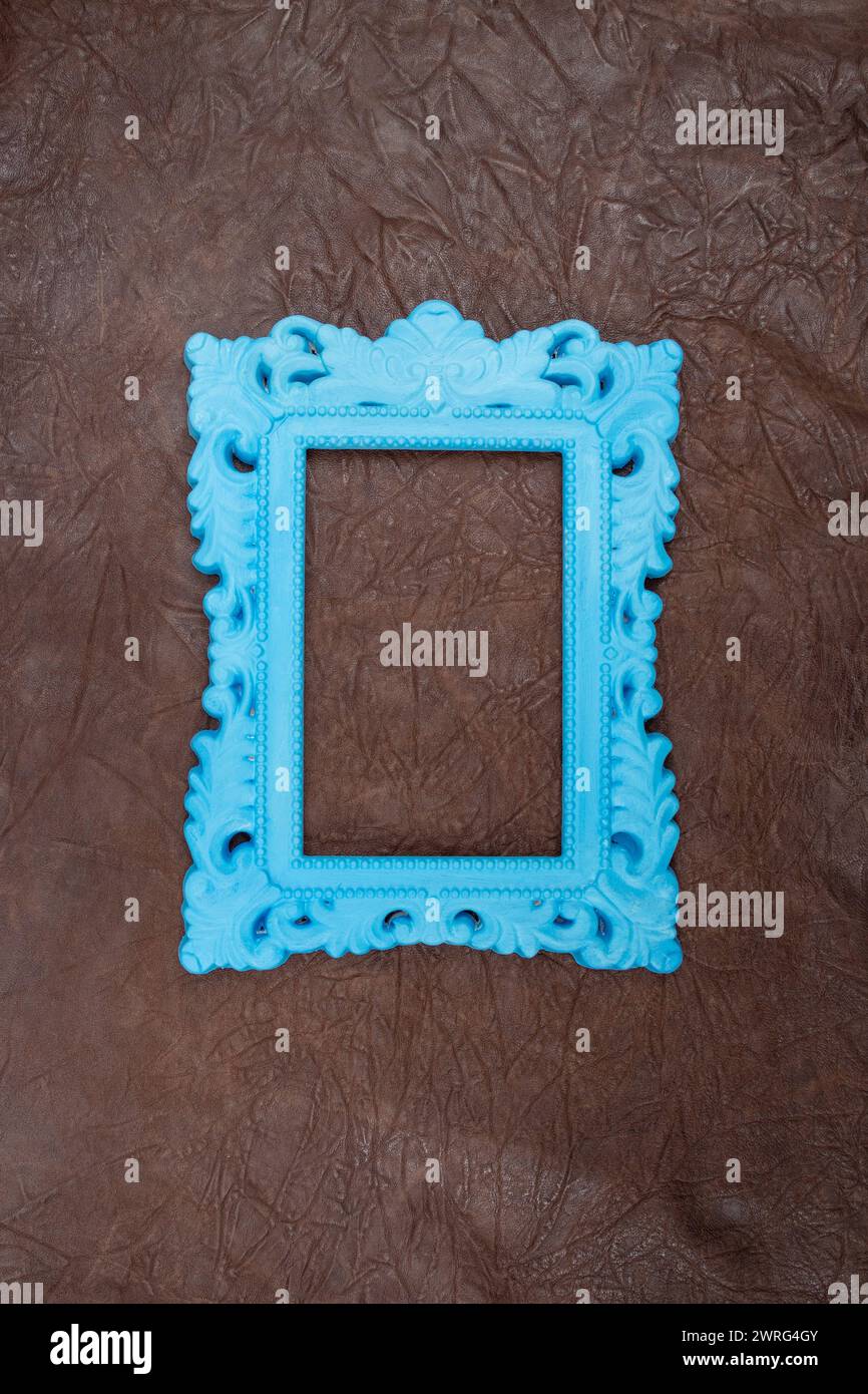 Empty blue painted baroque frame on genuine brown leather pattern, pop ...
