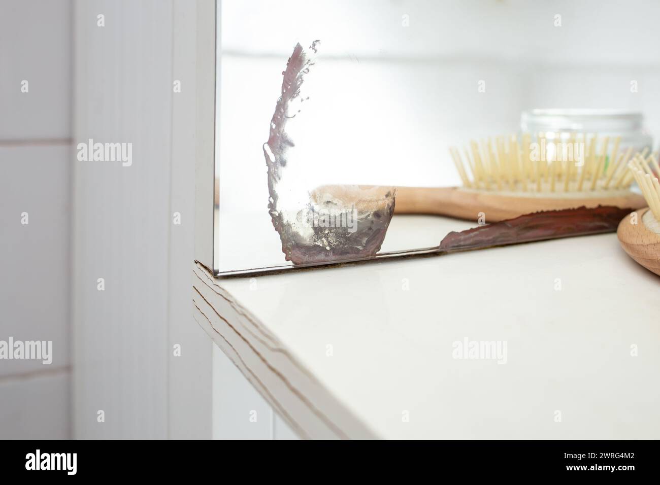 Damaged mirror corner and cracked wood shelf with defocused white ...