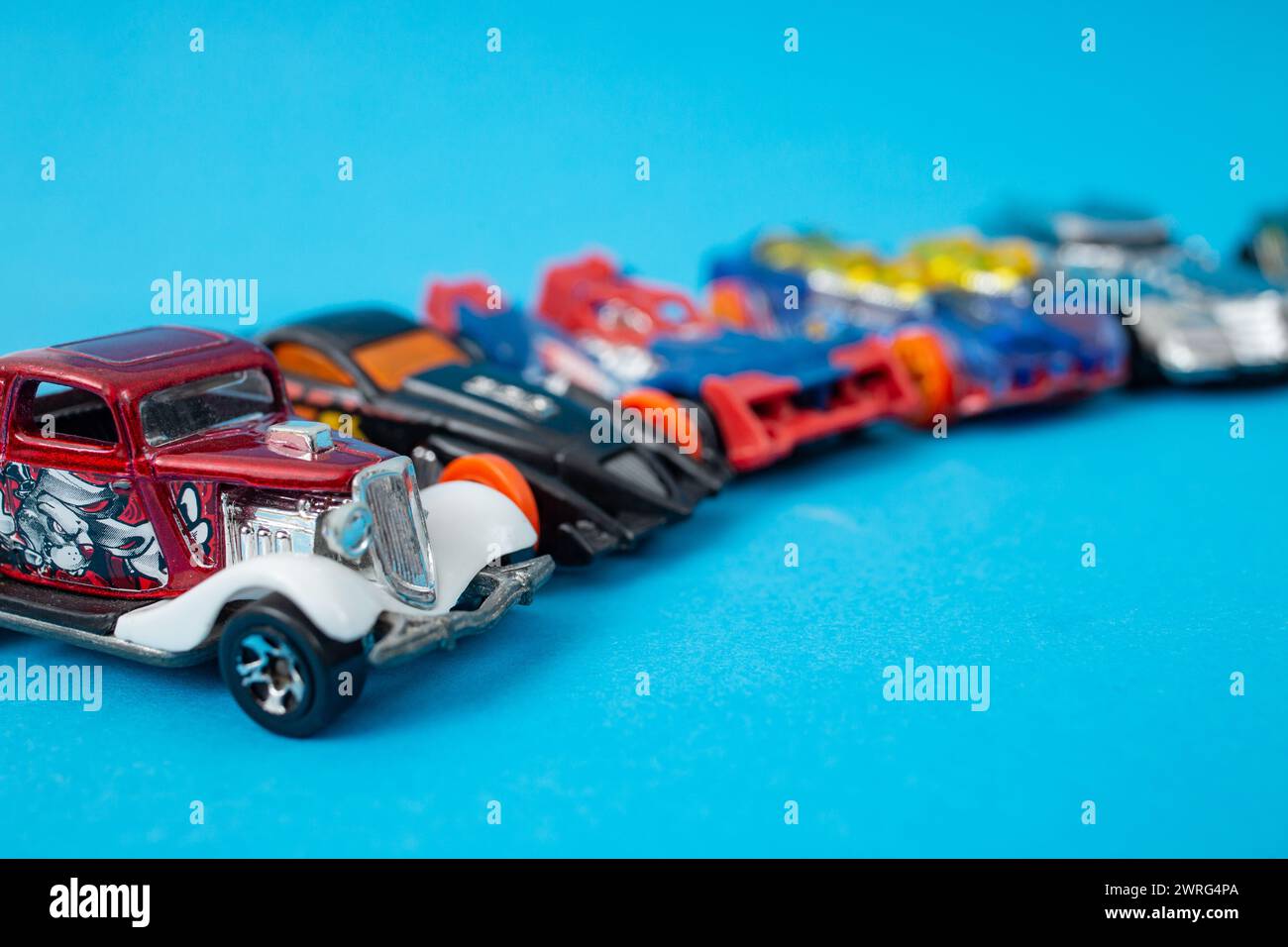 Multiple metallic die cast toy cars on blue background, soft focus ...