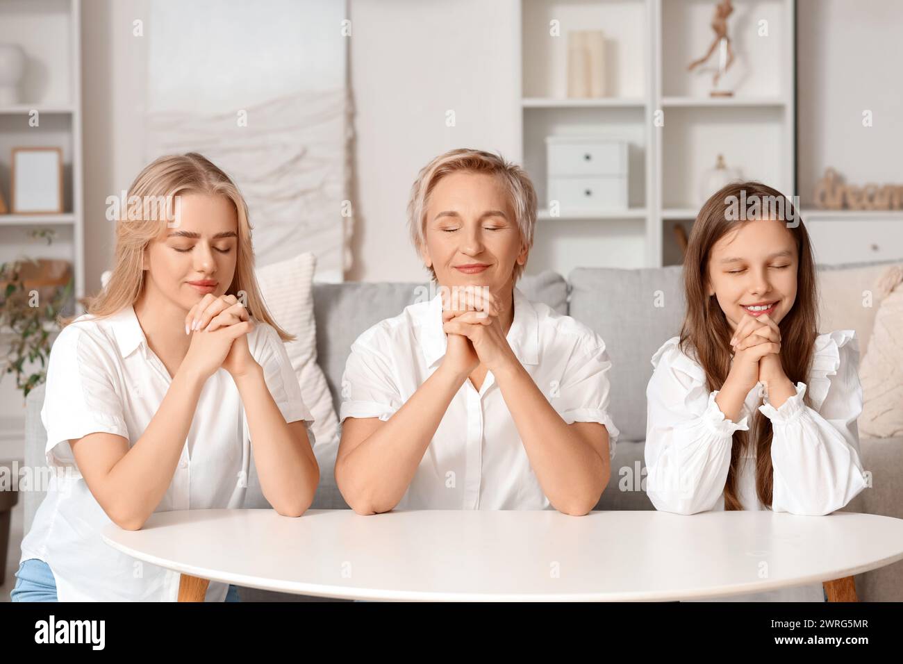 Little girl with her mom and grandmother praying at home Stock Photo ...