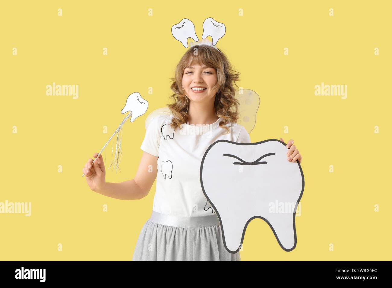 Tooth Fairy with wand and paper figure on yellow background Stock Photo ...