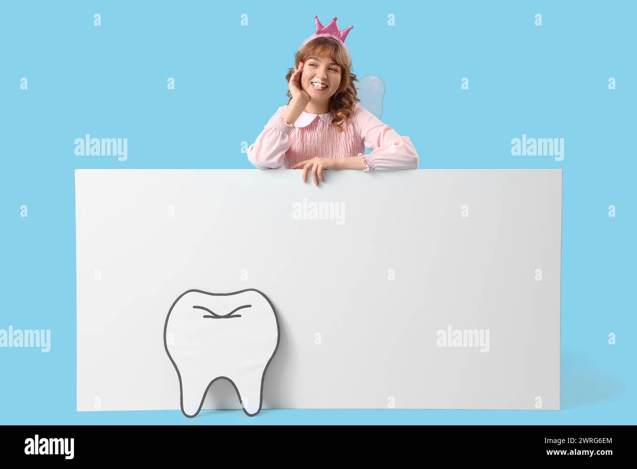 Tooth Fairy with blank poster and paper figure on blue background Stock ...