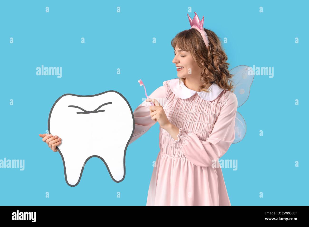 Tooth Fairy with paper figure and toothbrush on blue background Stock ...
