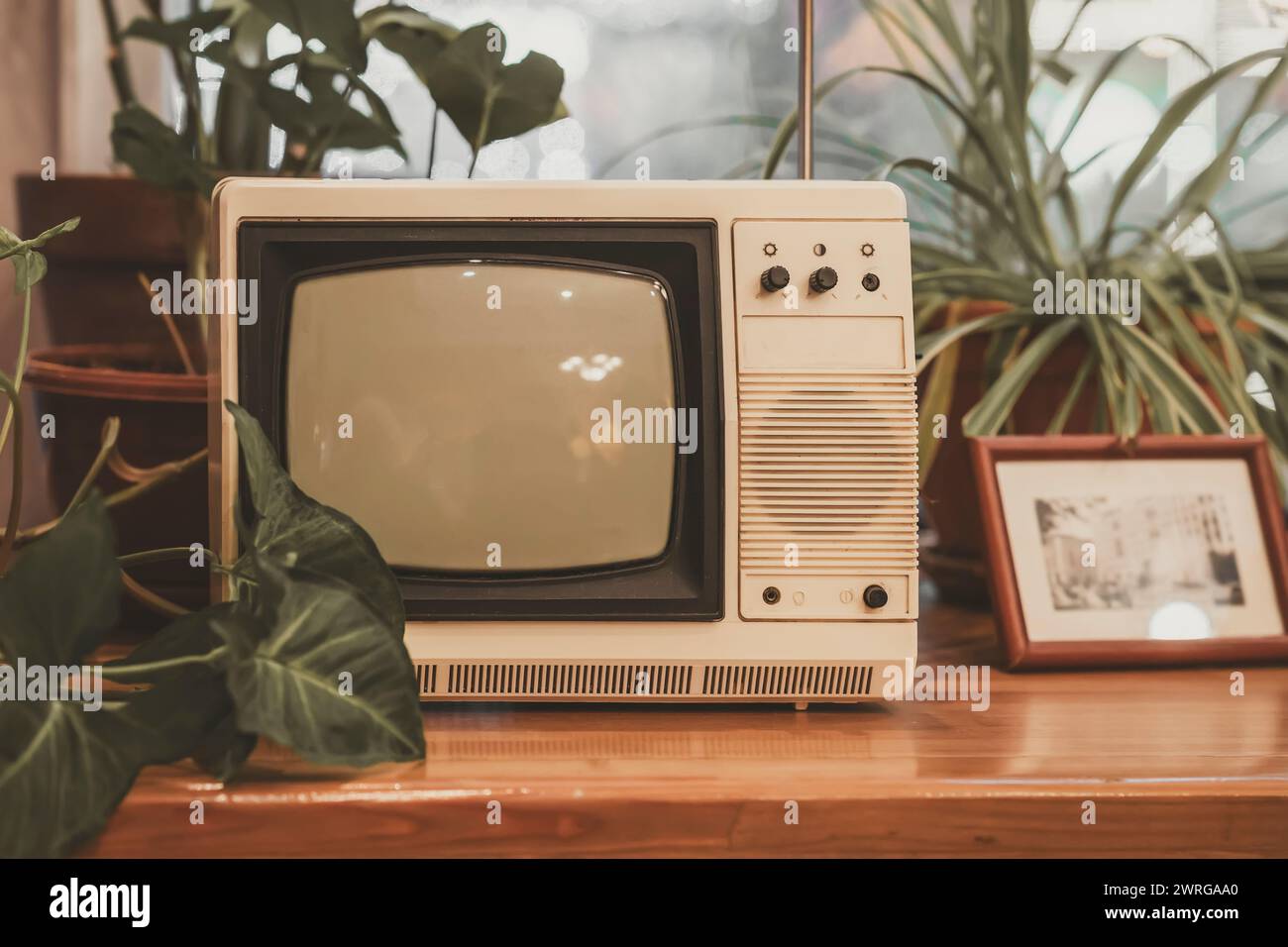 Retro tv set and picture frame, on wooden nightstand in room, old ...