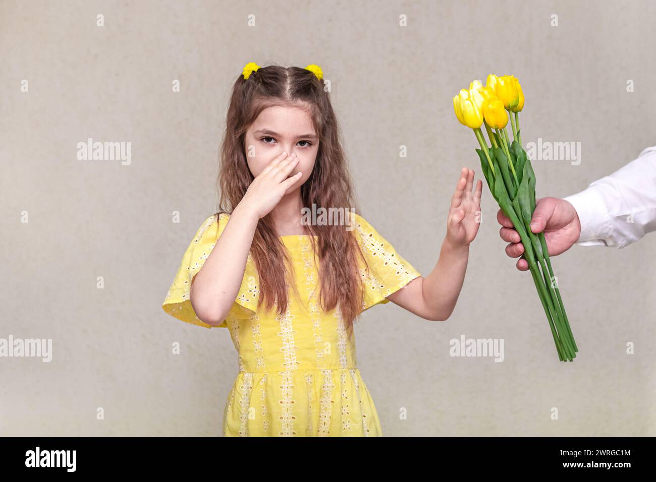 A girl refuses a bouquet of spring flowers to prevent allergy symptoms ...