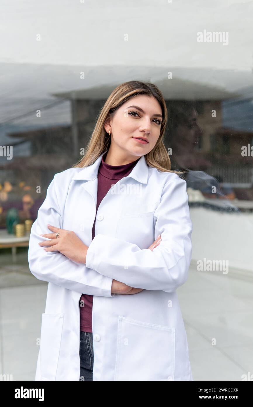 Vertical portrait of young Latina doctor with blonde hair and white ...