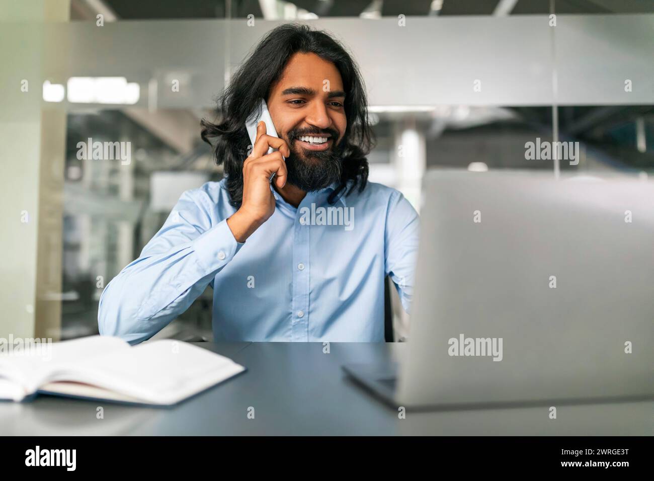 Eastern guy marketing director have phone call, office interior Stock ...