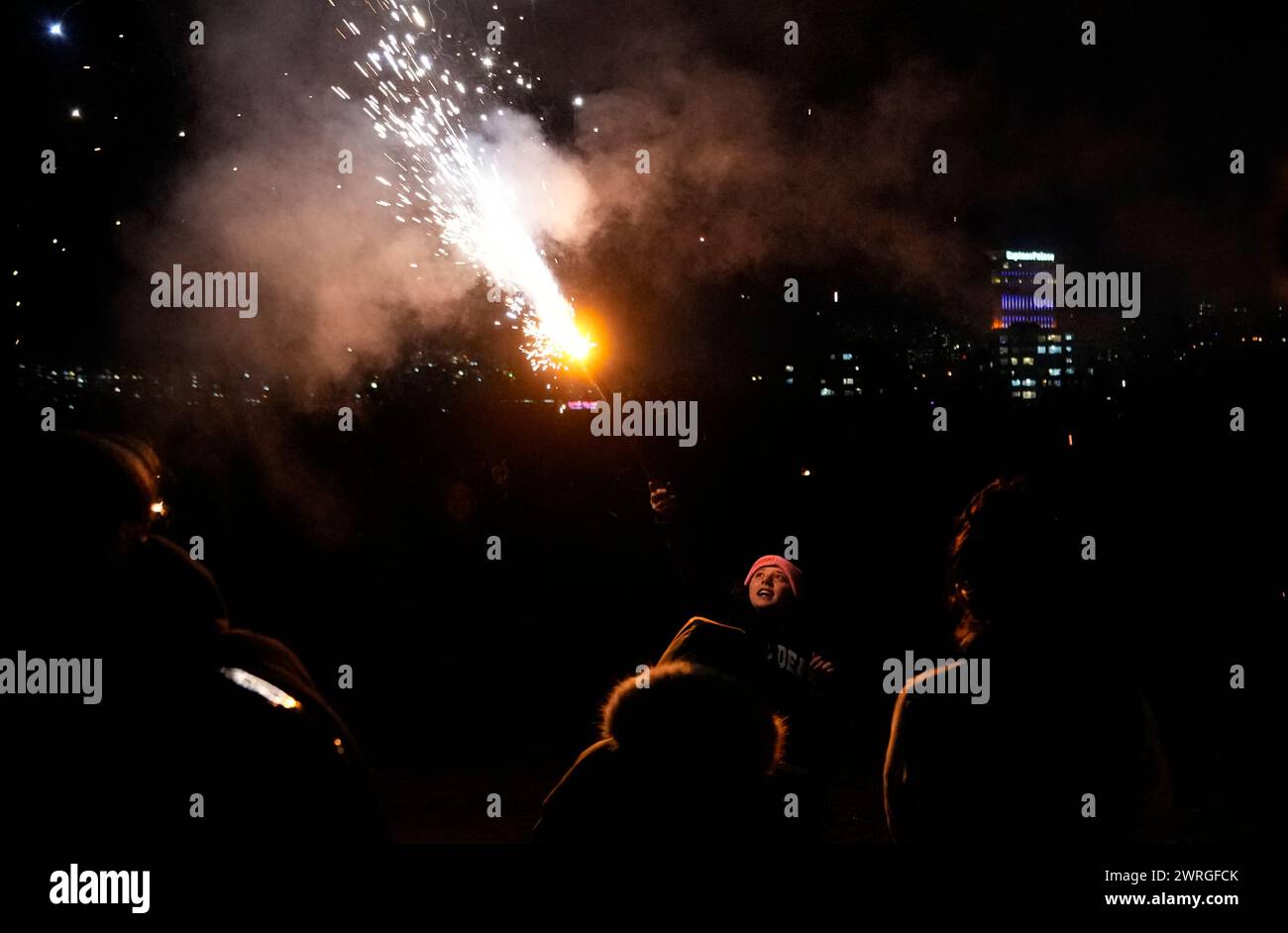 A youngster holds up a firework as people celebrate Chaharshanbe Souri ...
