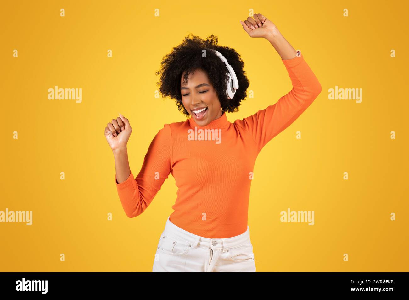 Happy young African American woman dancing with eyes closed and wearing ...