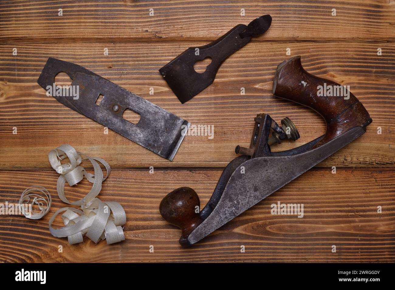 Woodworking plane disassembled with wood shaving on burnt wood ...