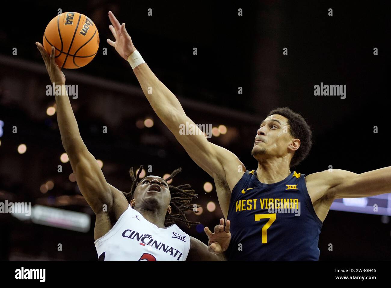 Cincinnati guard Jizzle James, left, shoots under pressure from West ...