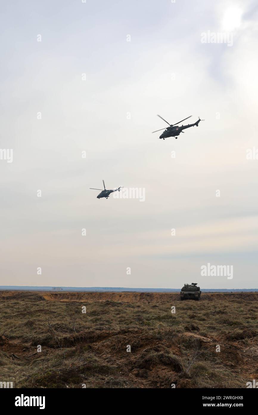 A pair of helicopters provide close air support as they fly over a ...