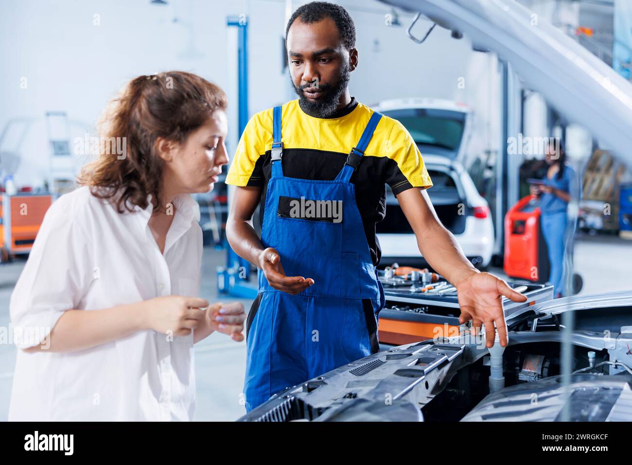 Repairman at auto repair shop conducts routine vehicle checkup ...