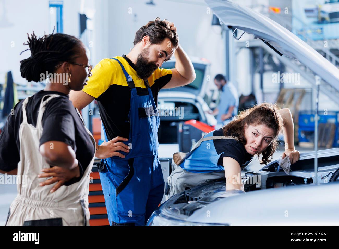 Diverse mechanics team in car service using professional mechanical ...