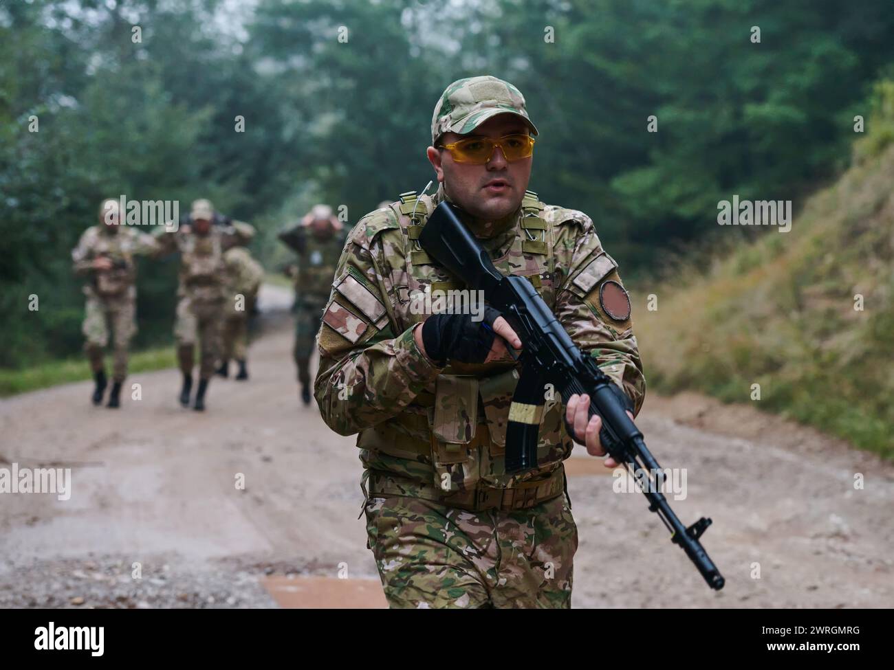 A group of elite soldiers leads captives through a military camp ...