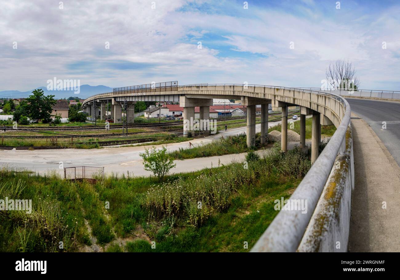 An overpass (bridge) built of concrete pillars and asphalt passes over ...