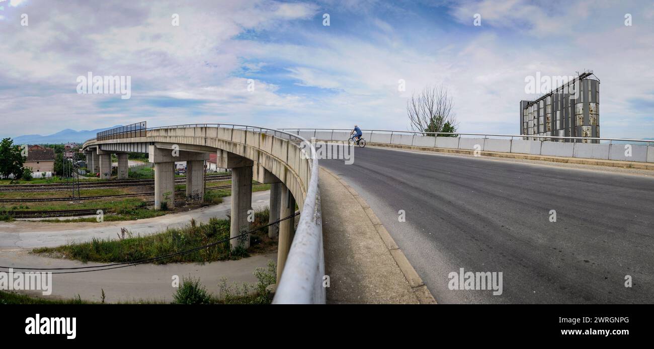 An overpass (bridge) built of concrete pillars and asphalt passes over ...