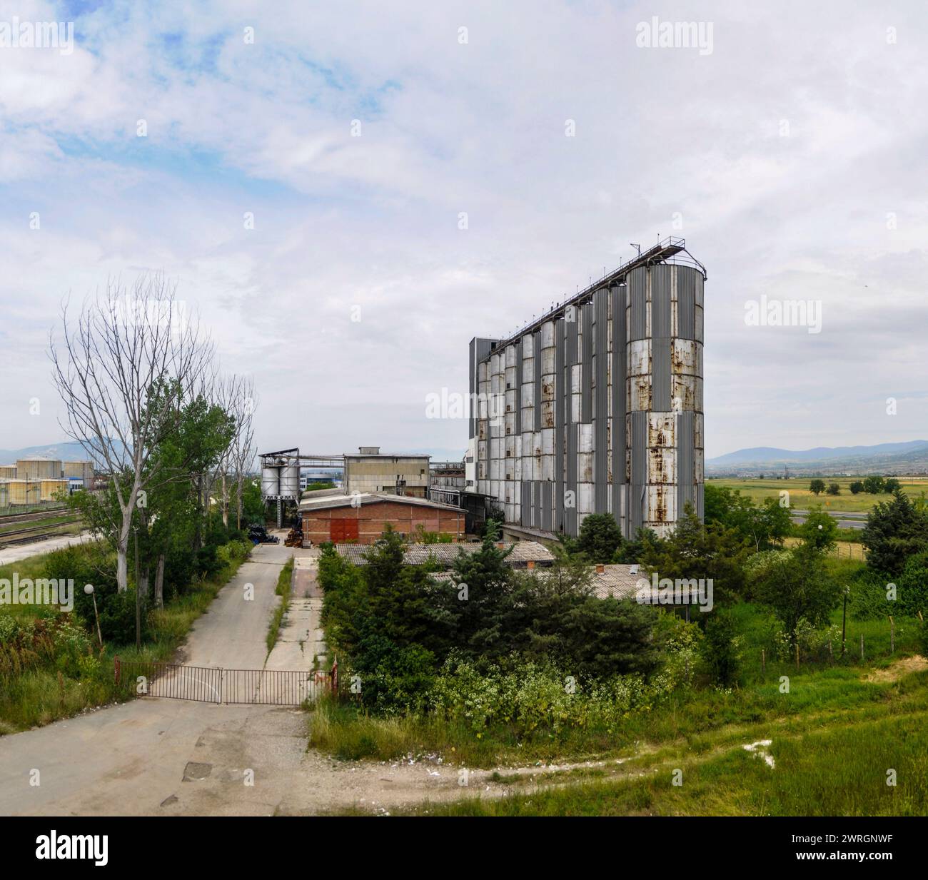 Old grain silos built alongside a highway and railroad Stock Photo - Alamy
