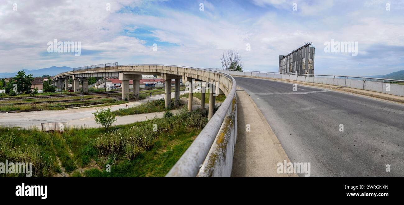 An overpass (bridge) built of concrete pillars and asphalt passes over ...