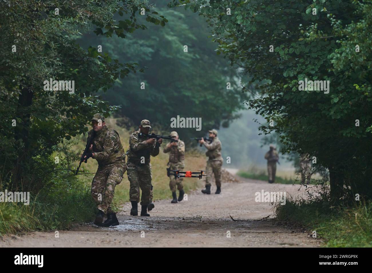 Elite military unit parading and securing the forest, utilizing drones ...