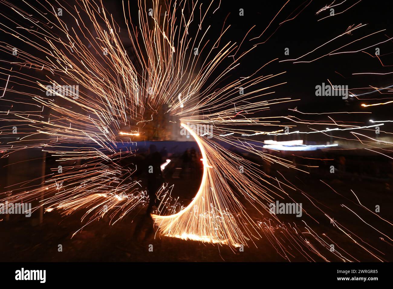 March 12, 2024, Tehran, Iran: An Iranian man turns a firework on the ...