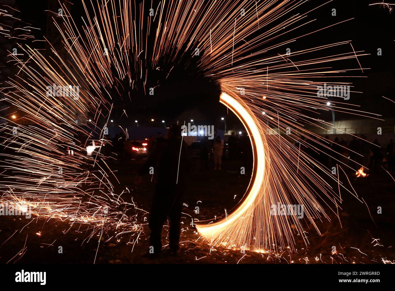 March 12, 2024, Tehran, Iran: An Iranian man turns a firework on the ...