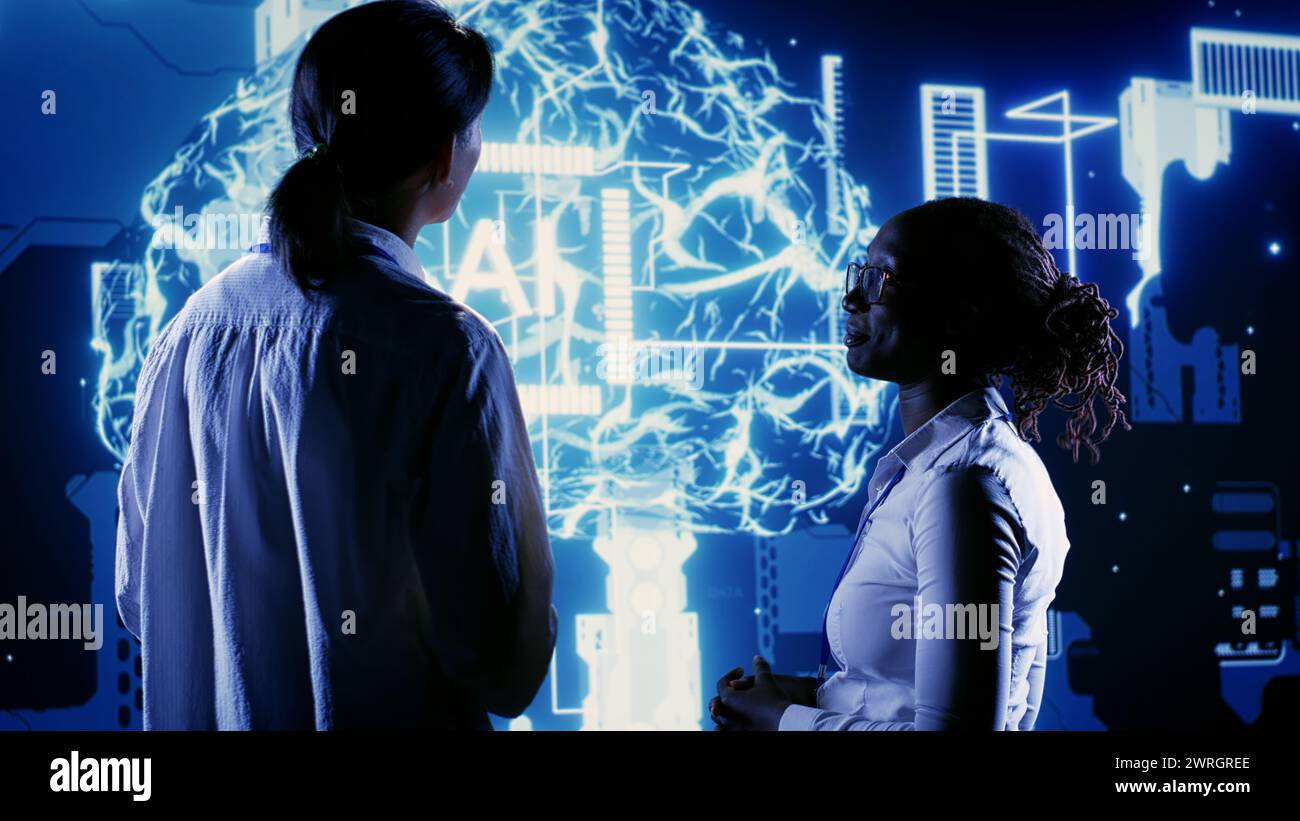 Licensed employees looking at hologram of artificial intelligence human brain simulation ...