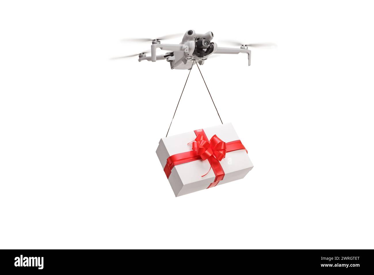 Aerial drone delivering a gift box with red ribbon isolated on white ...
