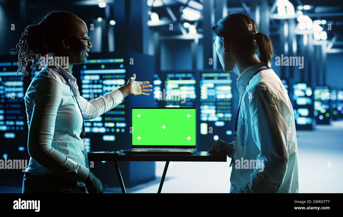 African american admin and colleague using mockup laptop to implement artificial intelligence ...