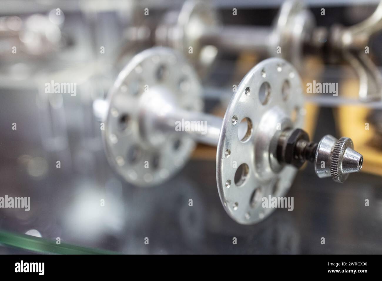 The bicycle axle is lying separately, with one side in focus, while the ...