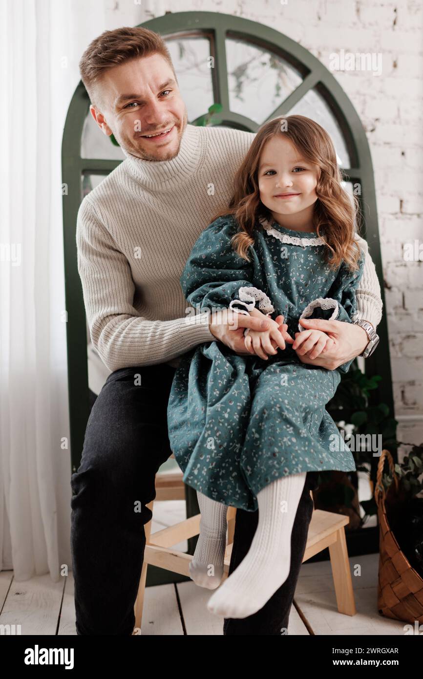 Happy Father's Day. Smiling young dad holds on knee his adorable little ...