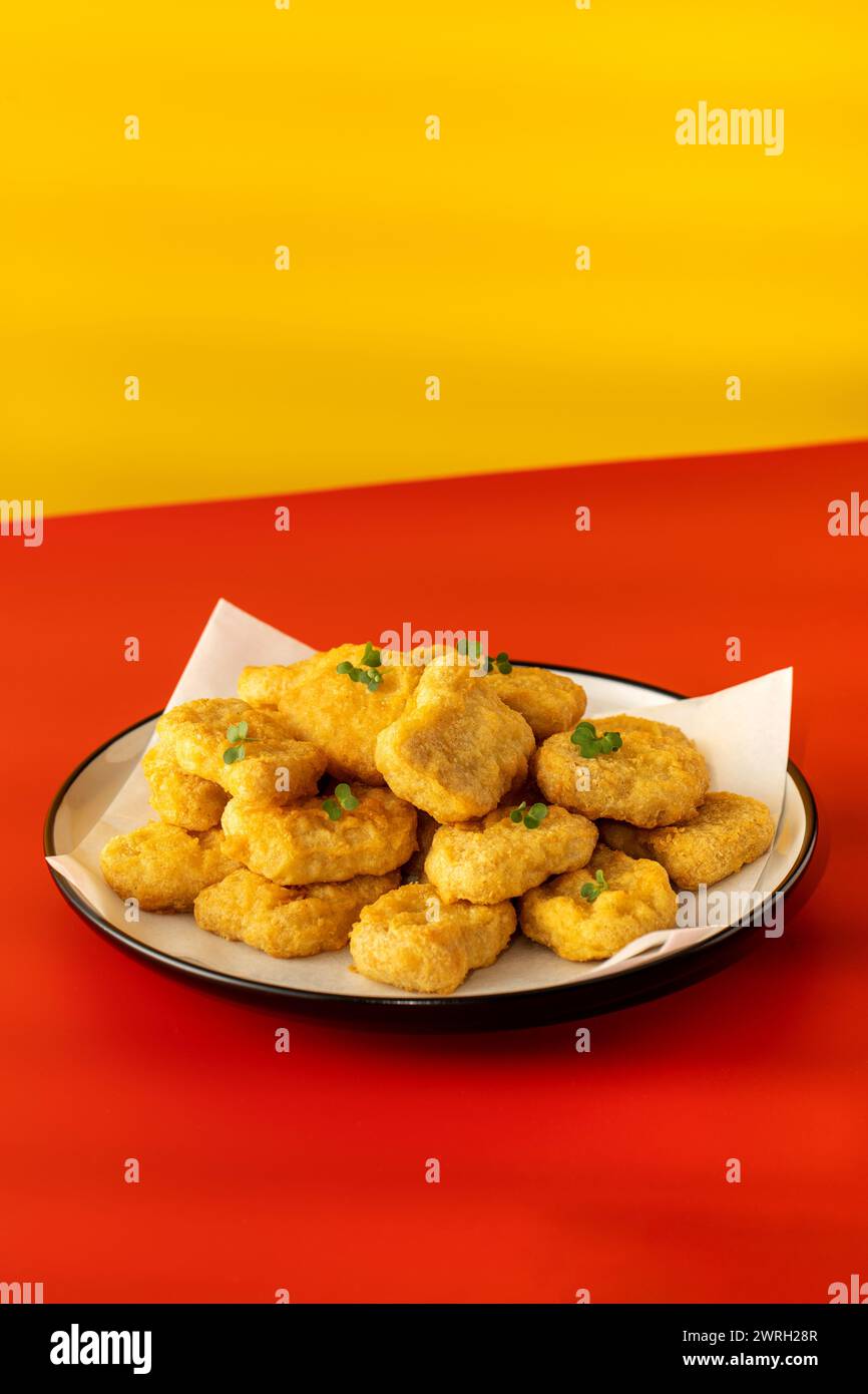Delicious golden chicken nuggets on a plate on the table. Fast food ...