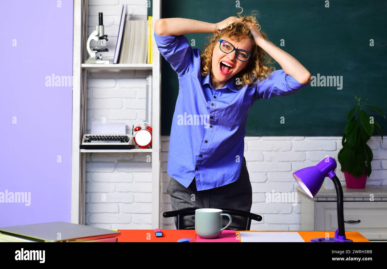 Angry displeased female teacher screaming in classroom. Student girl in ...