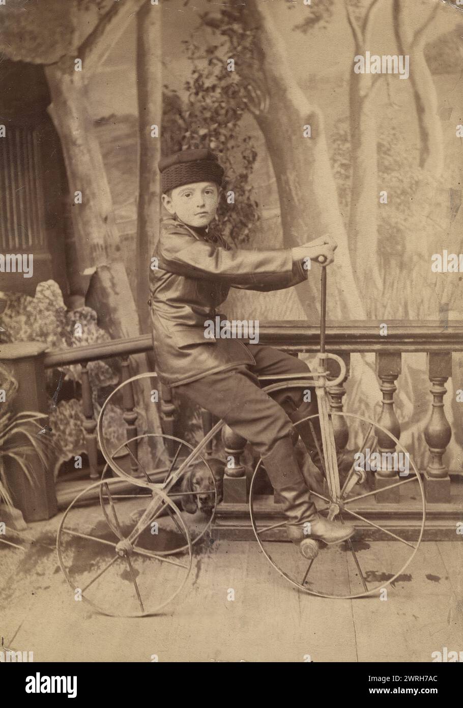 A boy on a bicycle in a photo studio, 1880. This collection includes ...