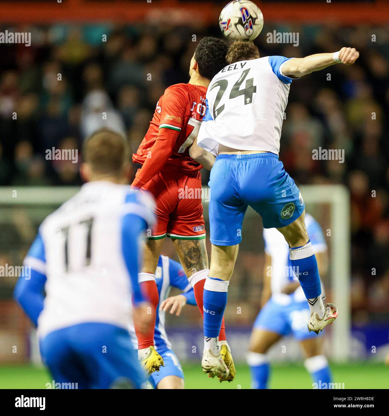 Walsall, UK. 12th Mar, 2024. Walsall's Joe Riley & Barrow's Rory Feely ...